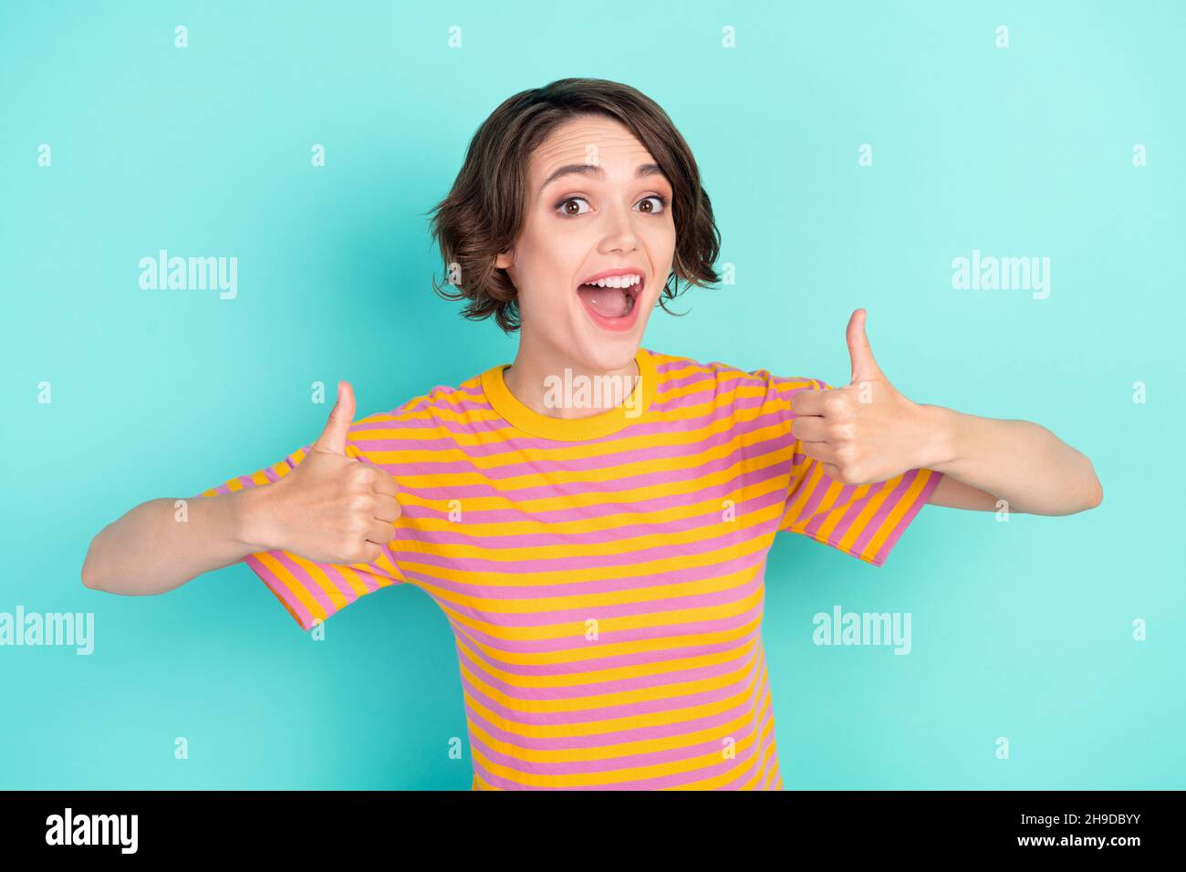 Photo of sweet impressed young woman dressed striped t-shirt smiling ...