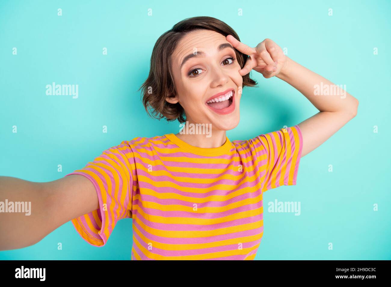 Photo of excited funny young woman dressed striped t-shirt tacking ...