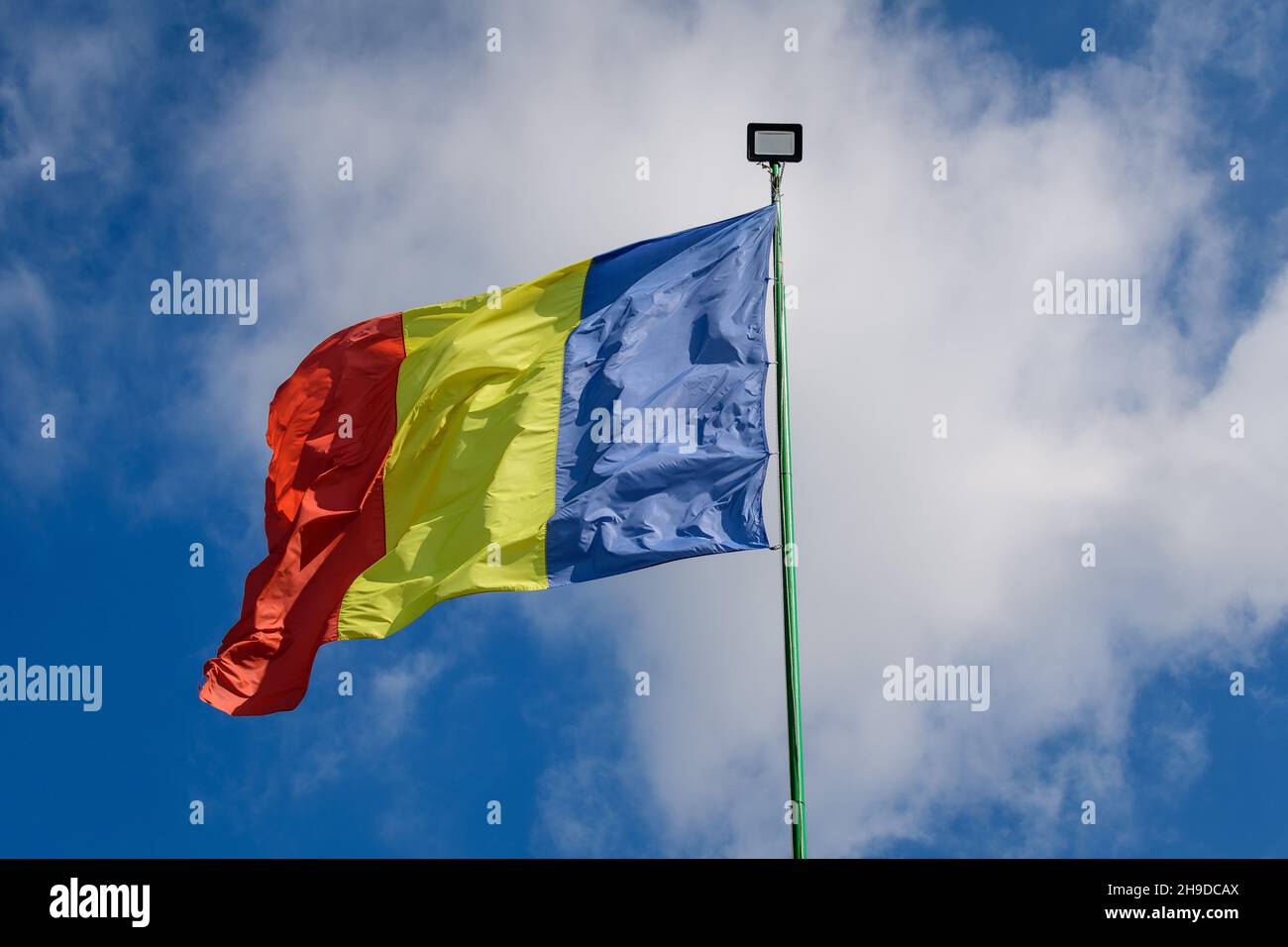 The Romanian national flags blowing in the wind in direct sunlight ...