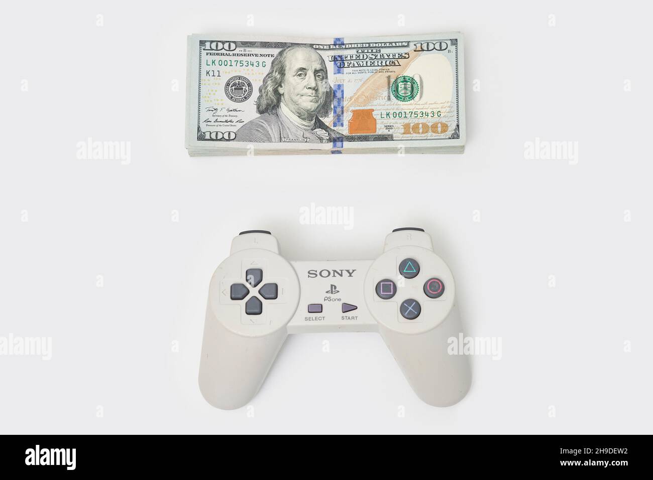 Game console controller and pile of money. Gamepad and us dollars ...