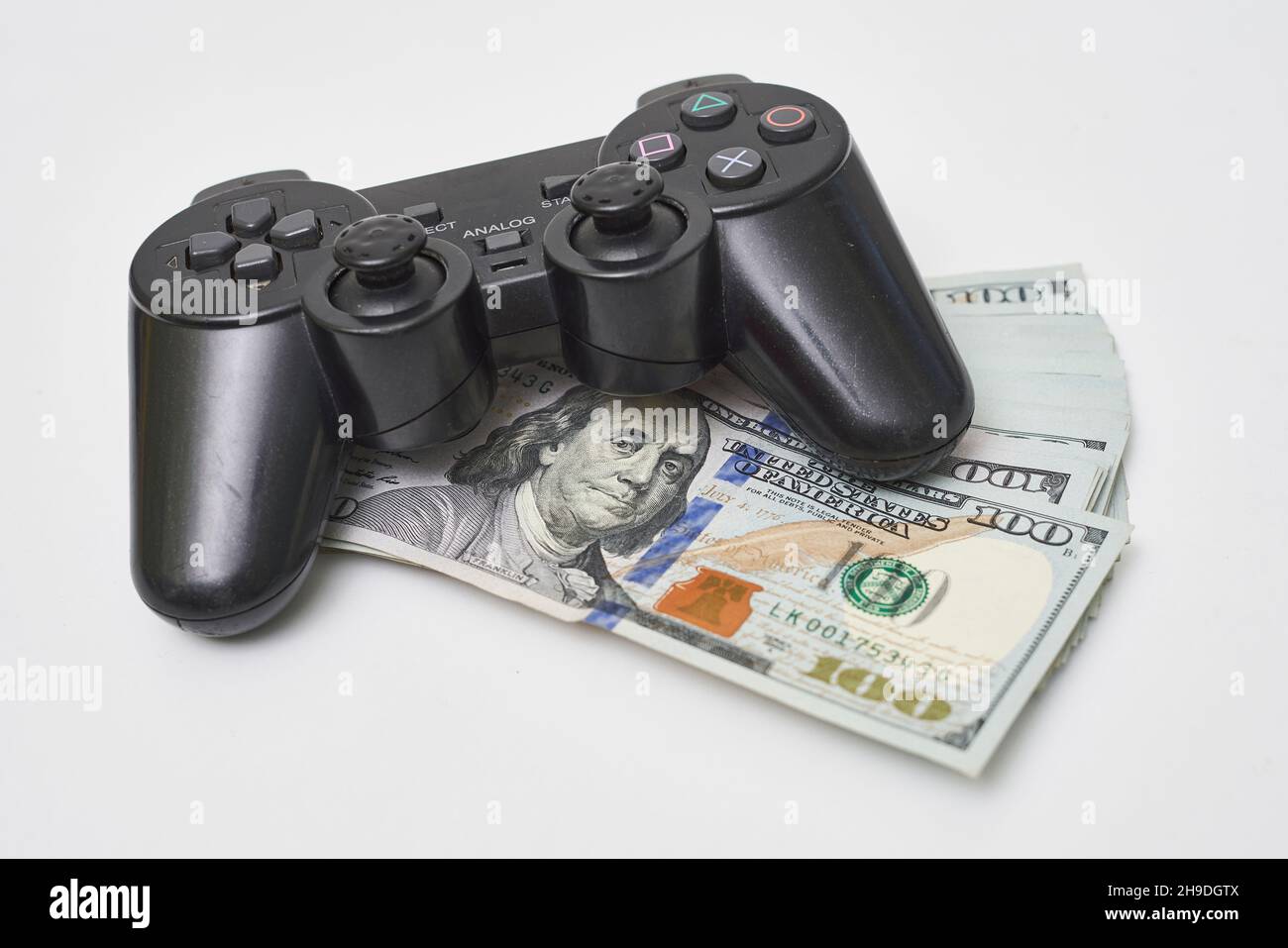 Game console controller and pile of money. Gamepad and us dollars ...