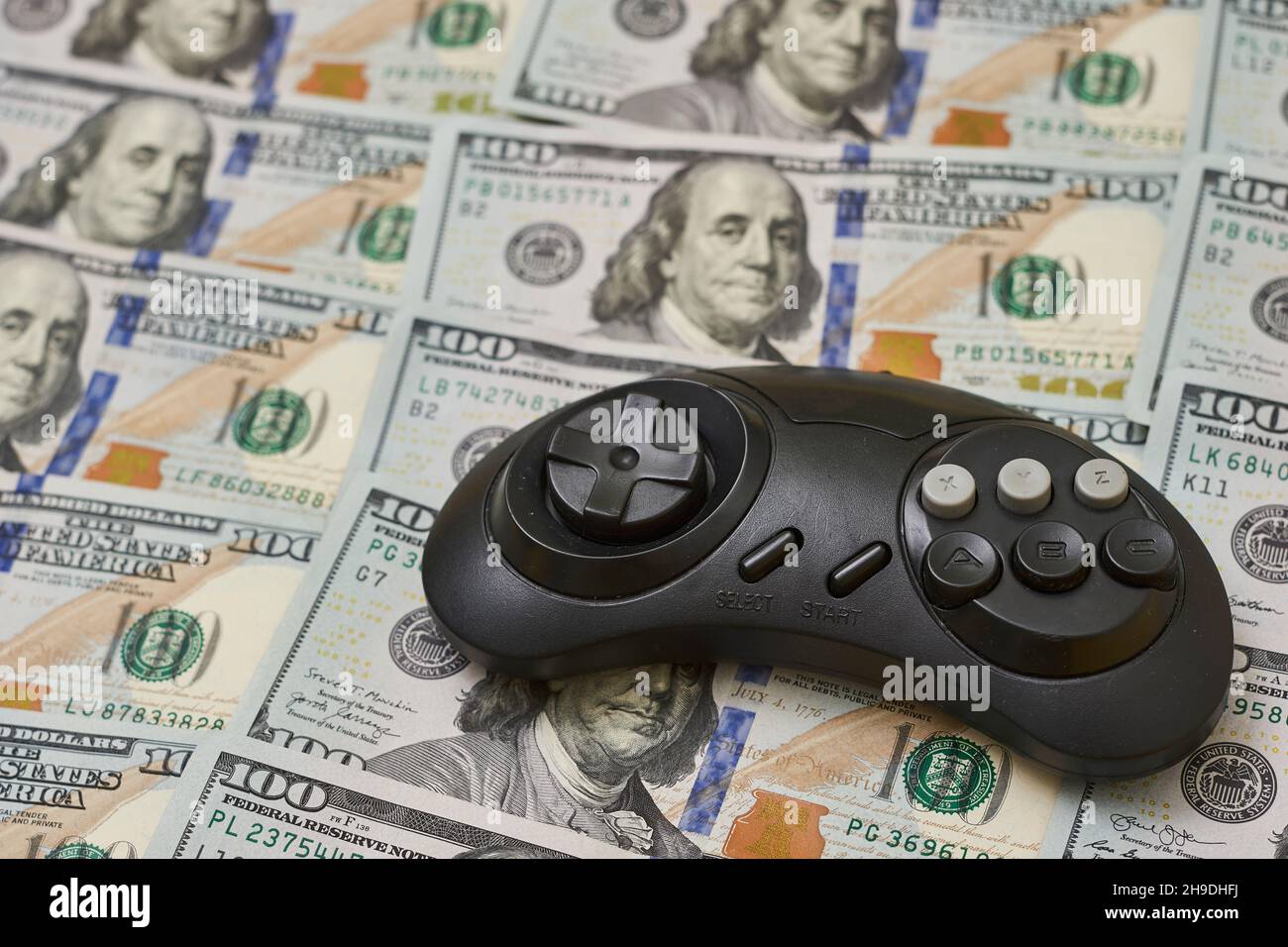 Game console controller and pile of money. Gamepad and us dollars ...