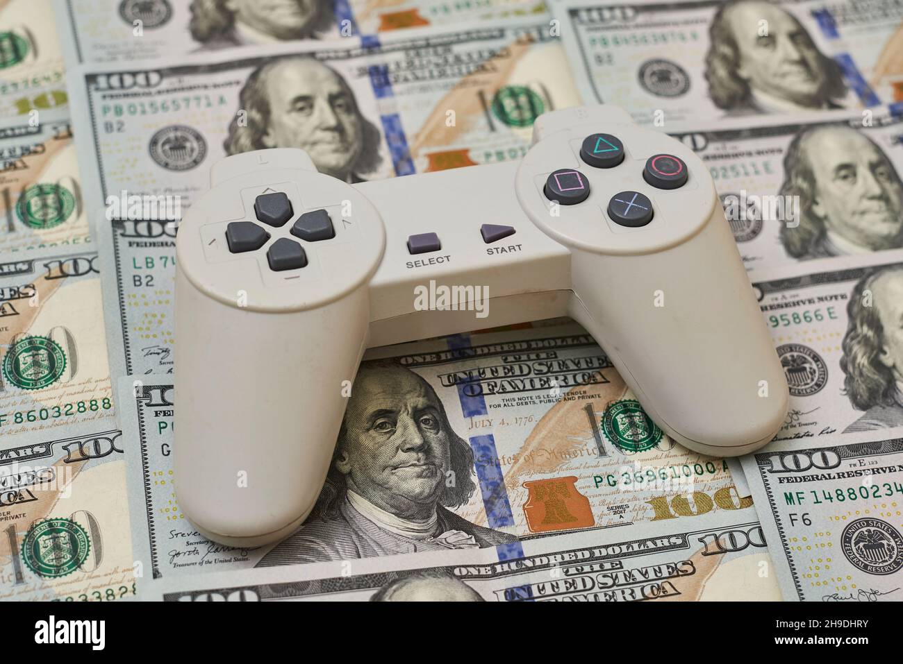 Game console controller and pile of money. Gamepad and us dollars ...