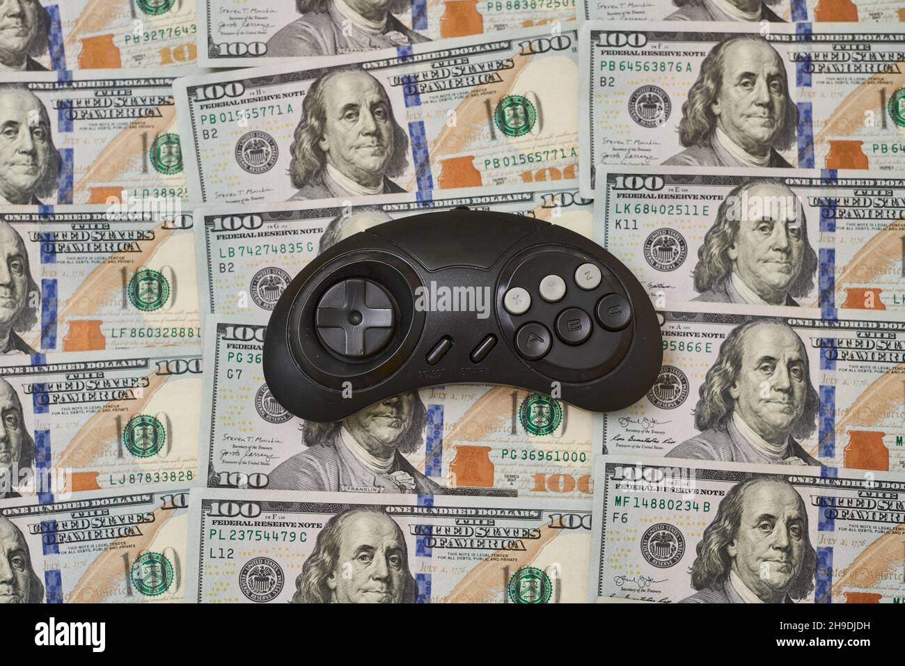 Game console controller and pile of money. Gamepad and us dollars ...