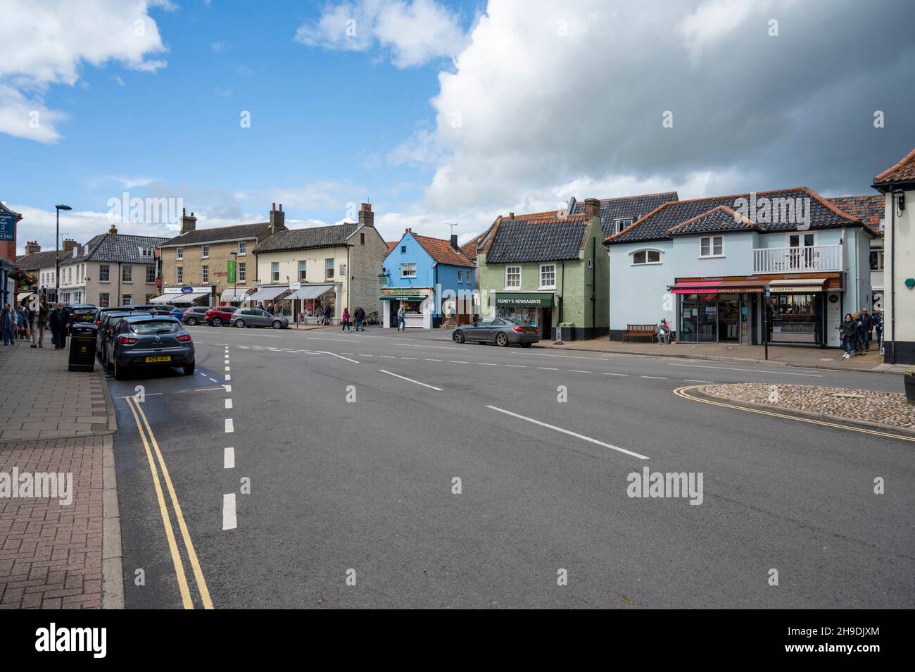 The main high street with shops, and parked cars in the market town of ...