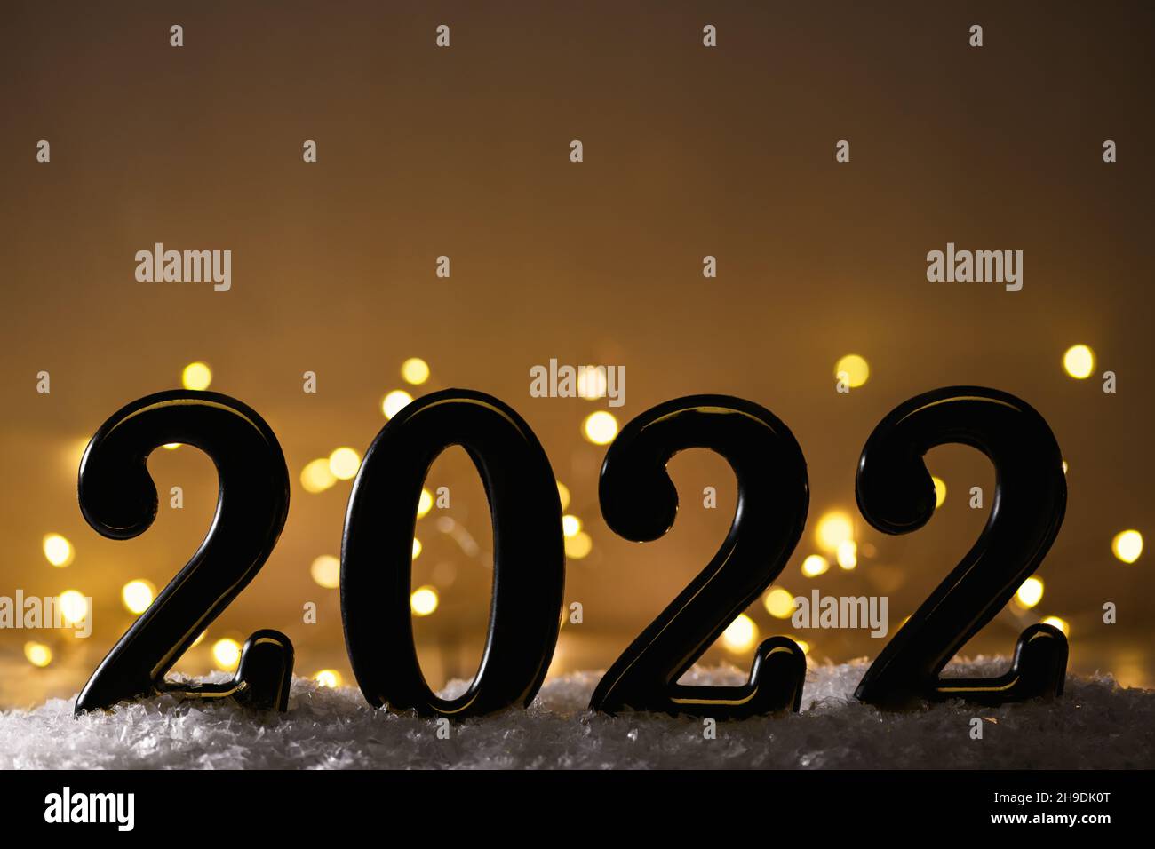 Black numbers 2022 on yellow background with luminous garland. New year ...