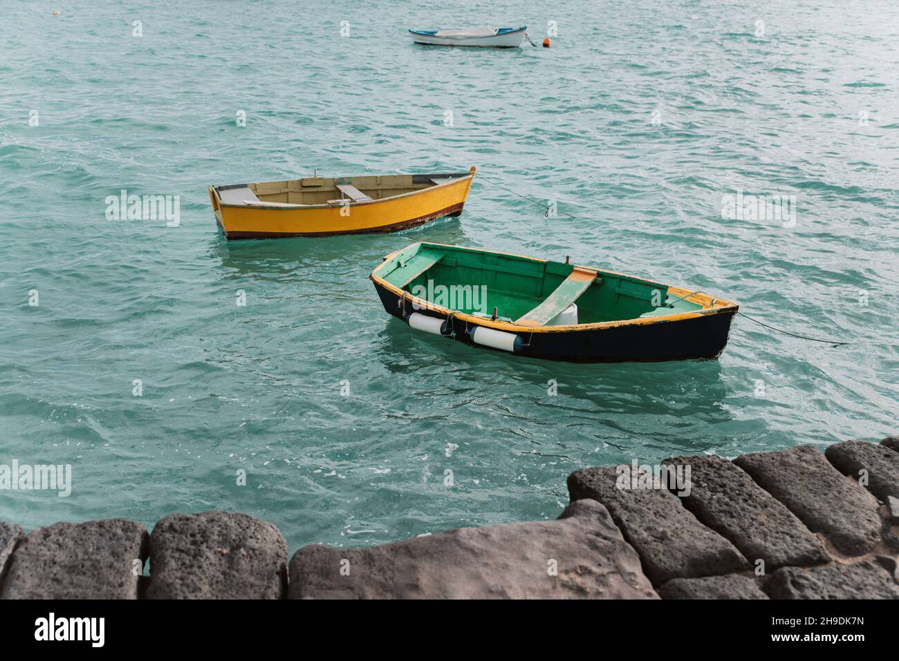 Three colored boats on the water Stock Photo - Alamy