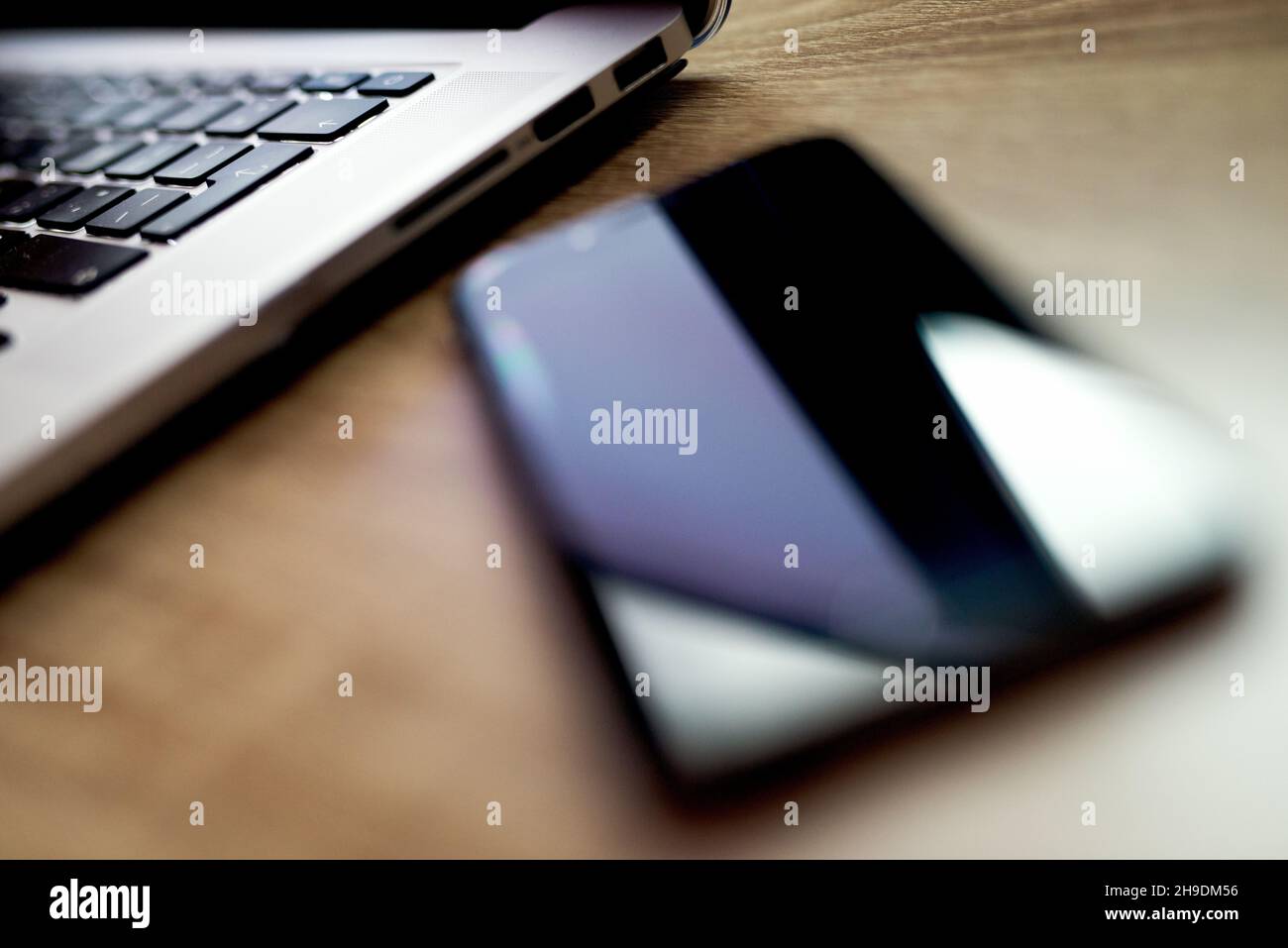 Side view of modern stylish laptop and modern thin smartphone left on ...