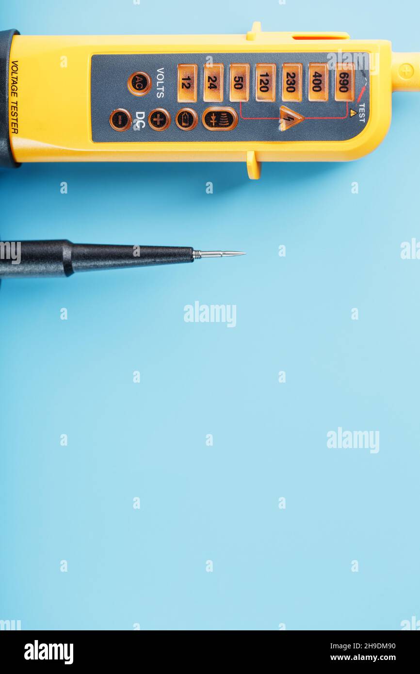 Two-pole voltage indicator close-up on a blue background. Testing and ...