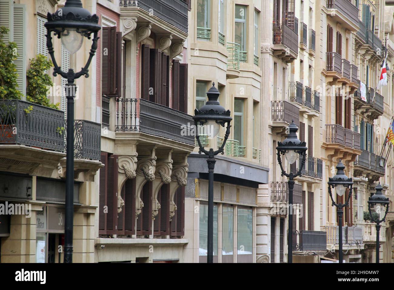 Beautiful view of street buildings with balconies, flags and lights ...