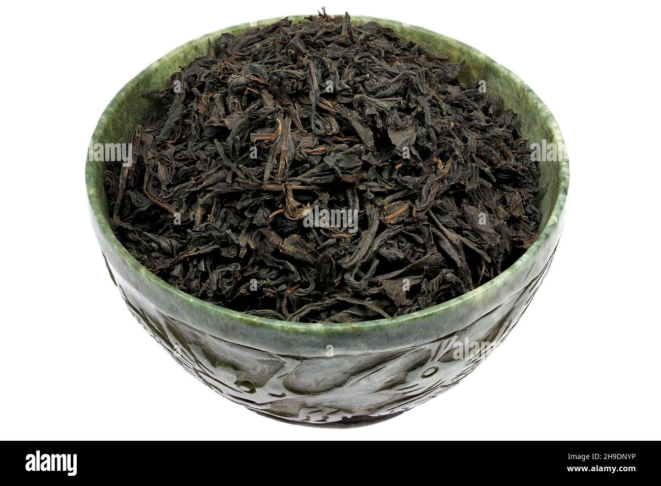 Ceylon Black Tea in a vintage jade bowl isolated on white background ...