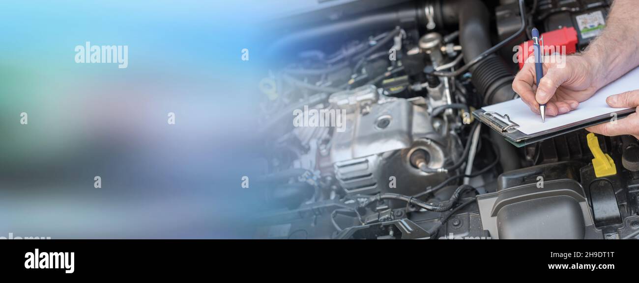 Car mechanic checking a car engine and writing on clipboard Stock Photo ...