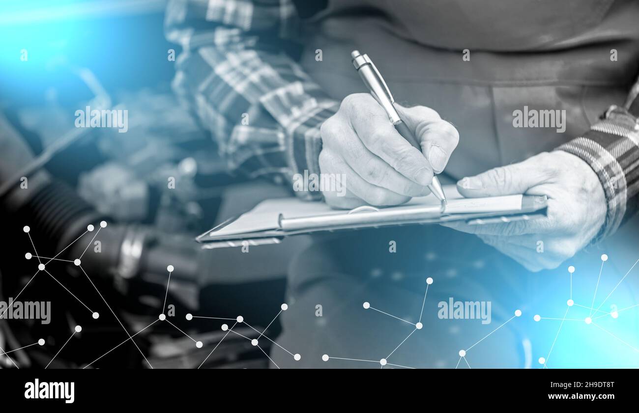 Car mechanic checking a car engine and writing on clipboard; light ...