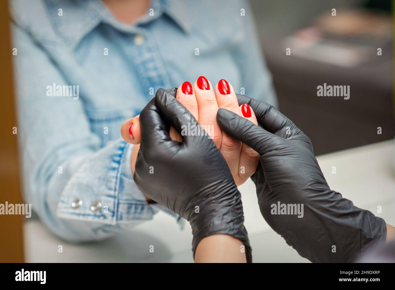 Examination of manicured fingernails. Hands of manicure master in black ...