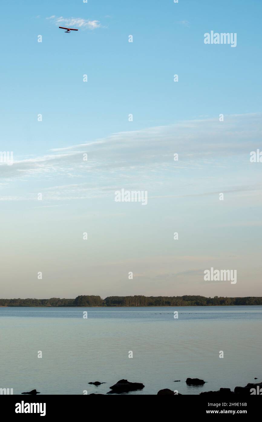 red plane flying on a blue sky Stock Photo - Alamy