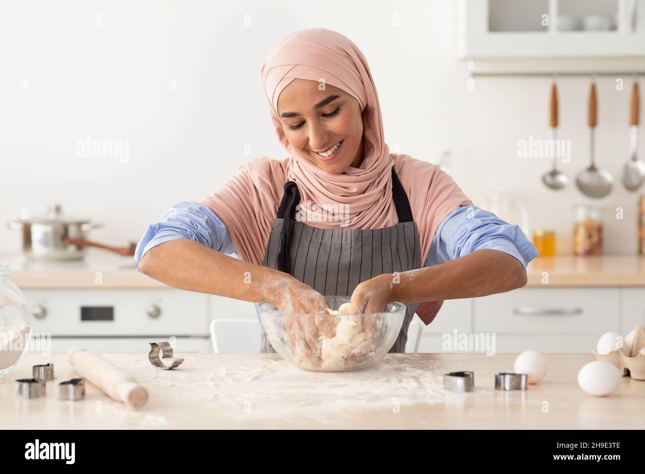 Happy Young Muslim Woman Wearing Hijab And Apron Baking In Kitchen ...