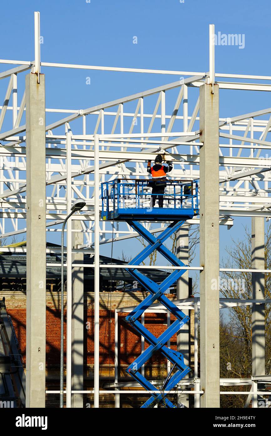 worker in uniform and safety protective equipment on self propelled ...