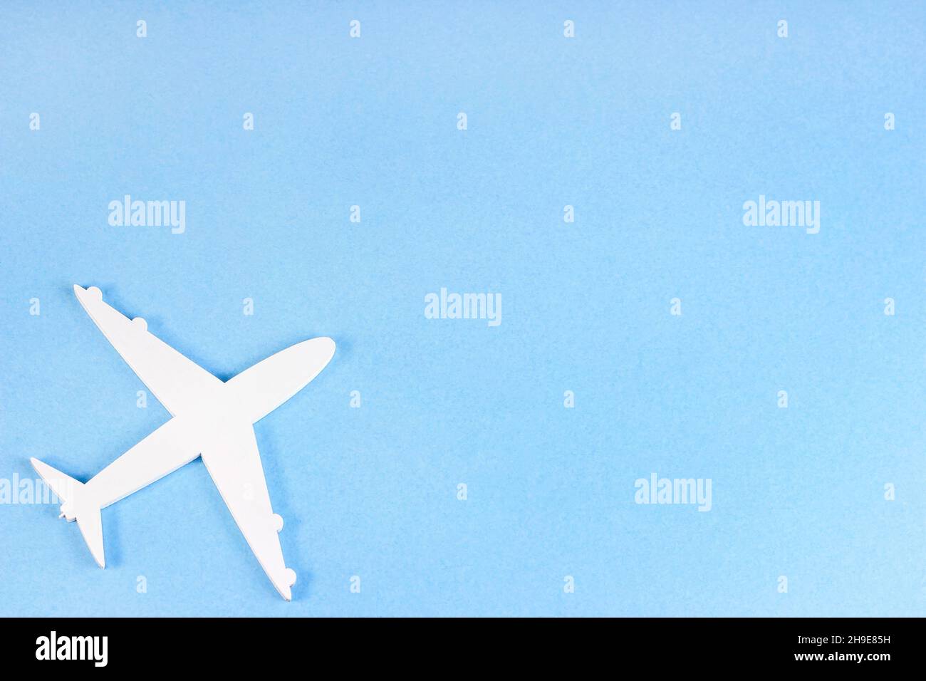 Top view flat lay of white plane model on light sky blue background ...