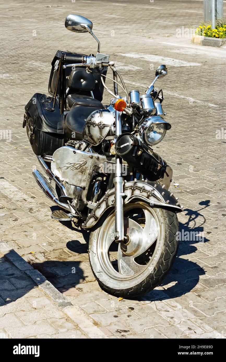 Black retro motorcycle chopper stands on site without driver. View from ...