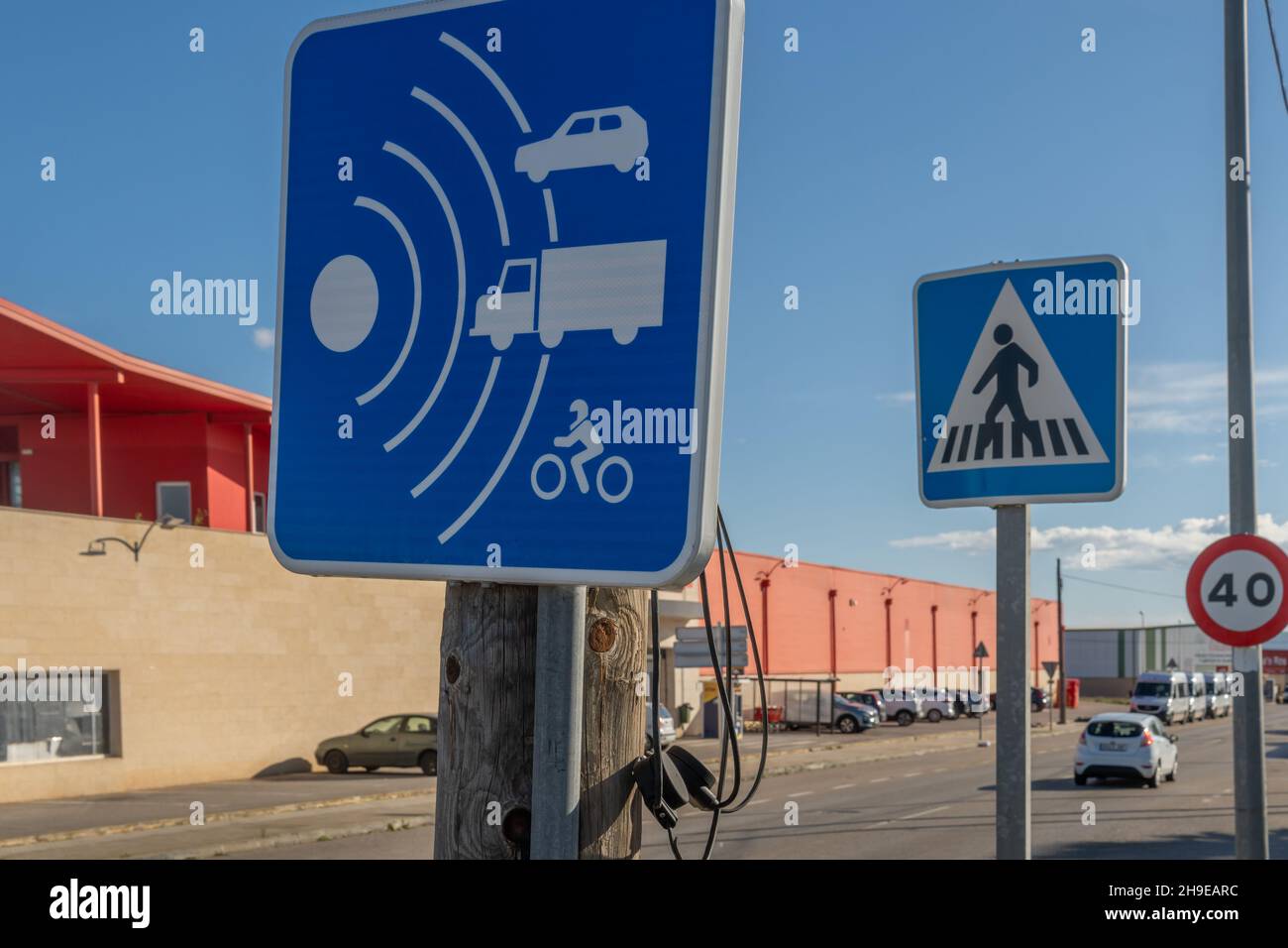 Blue speed control sign for vehicles on the street. In the background ...