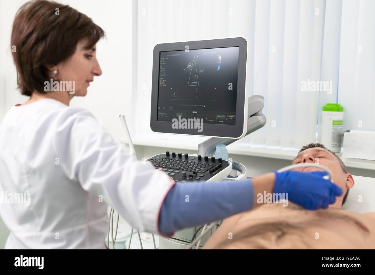 Doctor doing a doppler sonography a male patient in a cardiology clinic ...