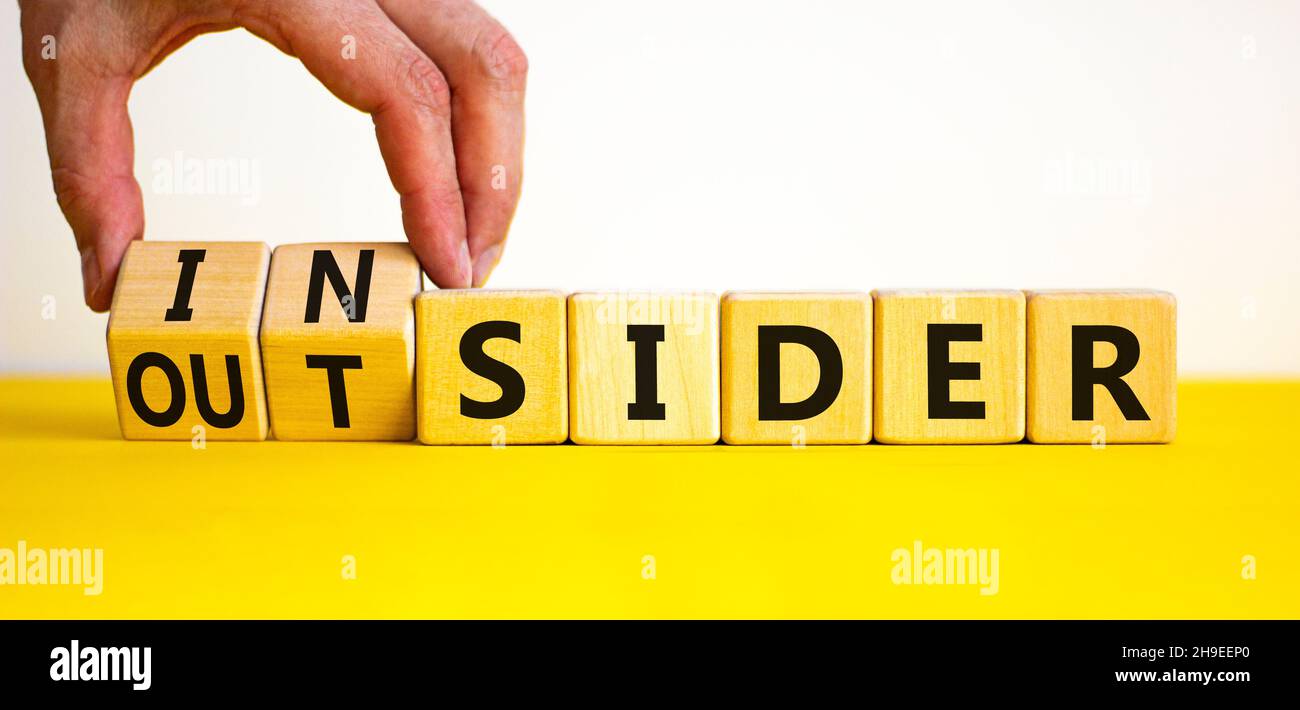 Insider or outsider symbol. Businessman turns a cube, changes the word ...