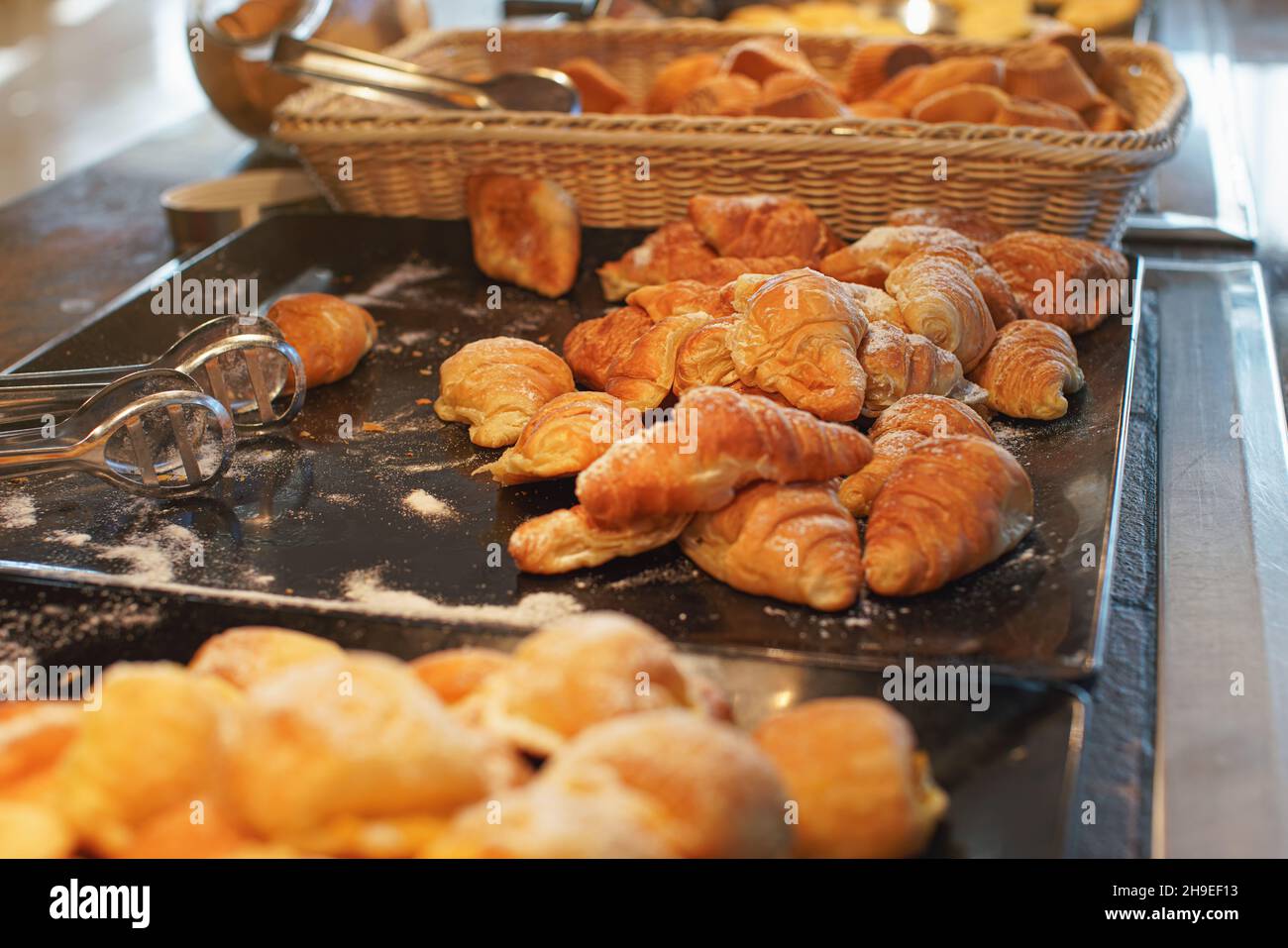 Sweet pastry pieces sprinkled with sugar displayed in dining hall of ...