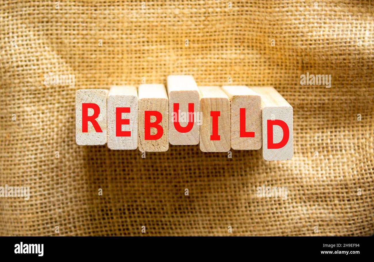 Rebuild and build symbol. The concept word Rebuild on wooden blocks ...