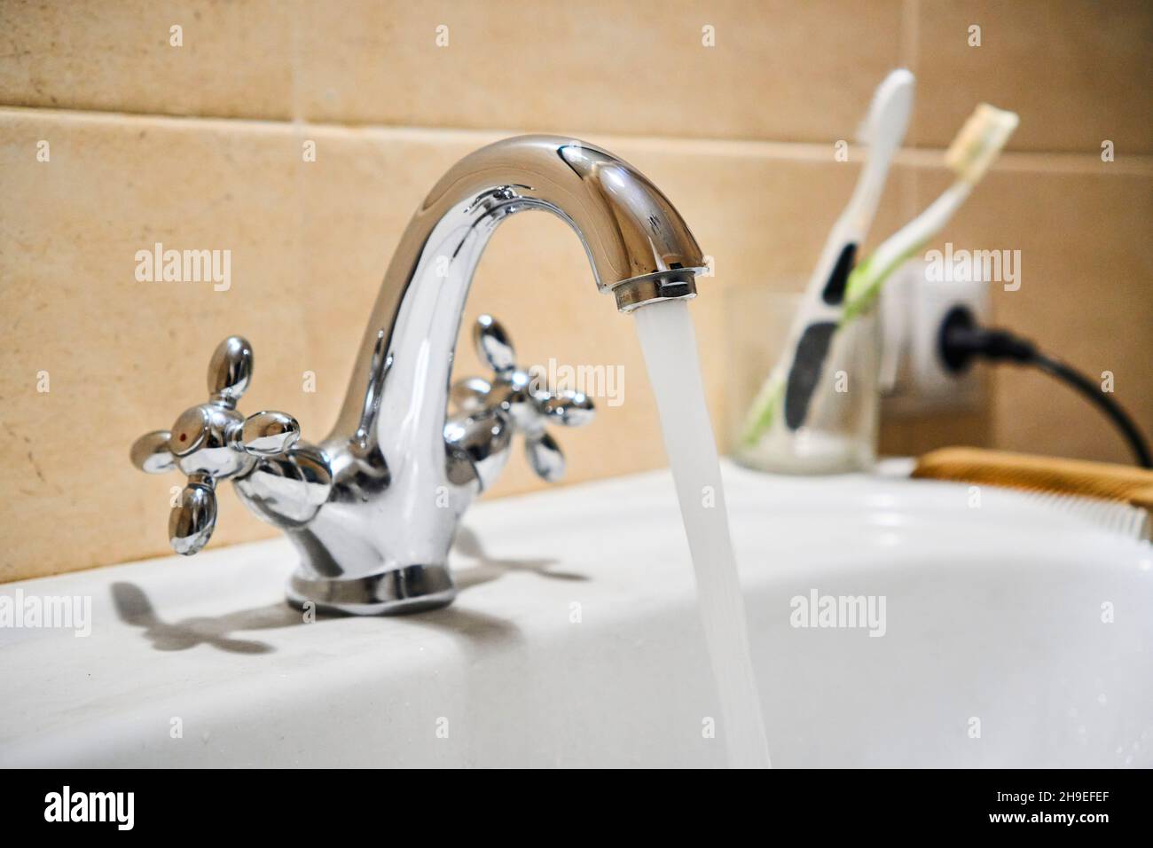 Common mixer tap. Water flowing out of bathroom stainless steel pillar ...