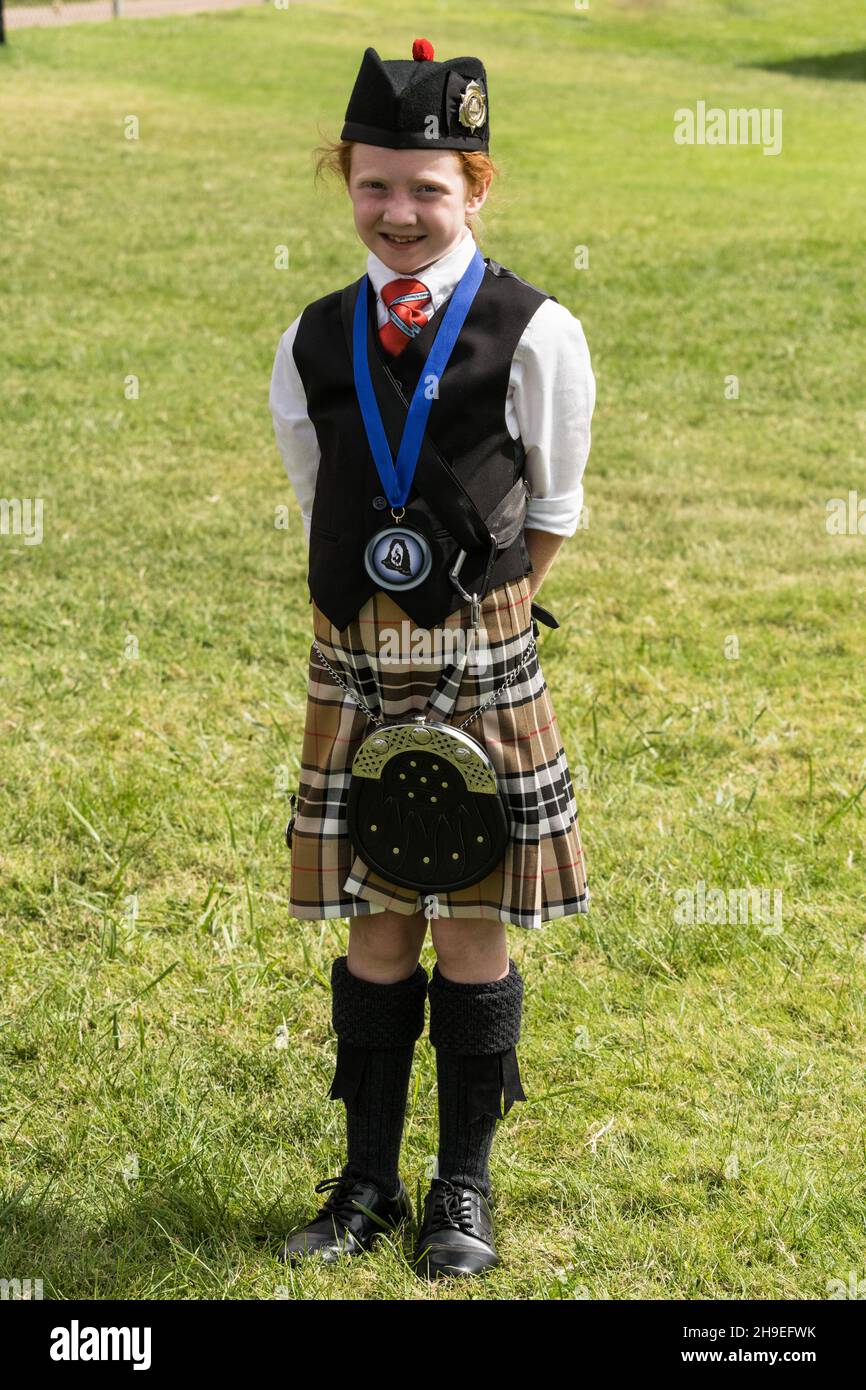 A young member of a Highland Scottish pipe band in her Glengarry bonnet ...