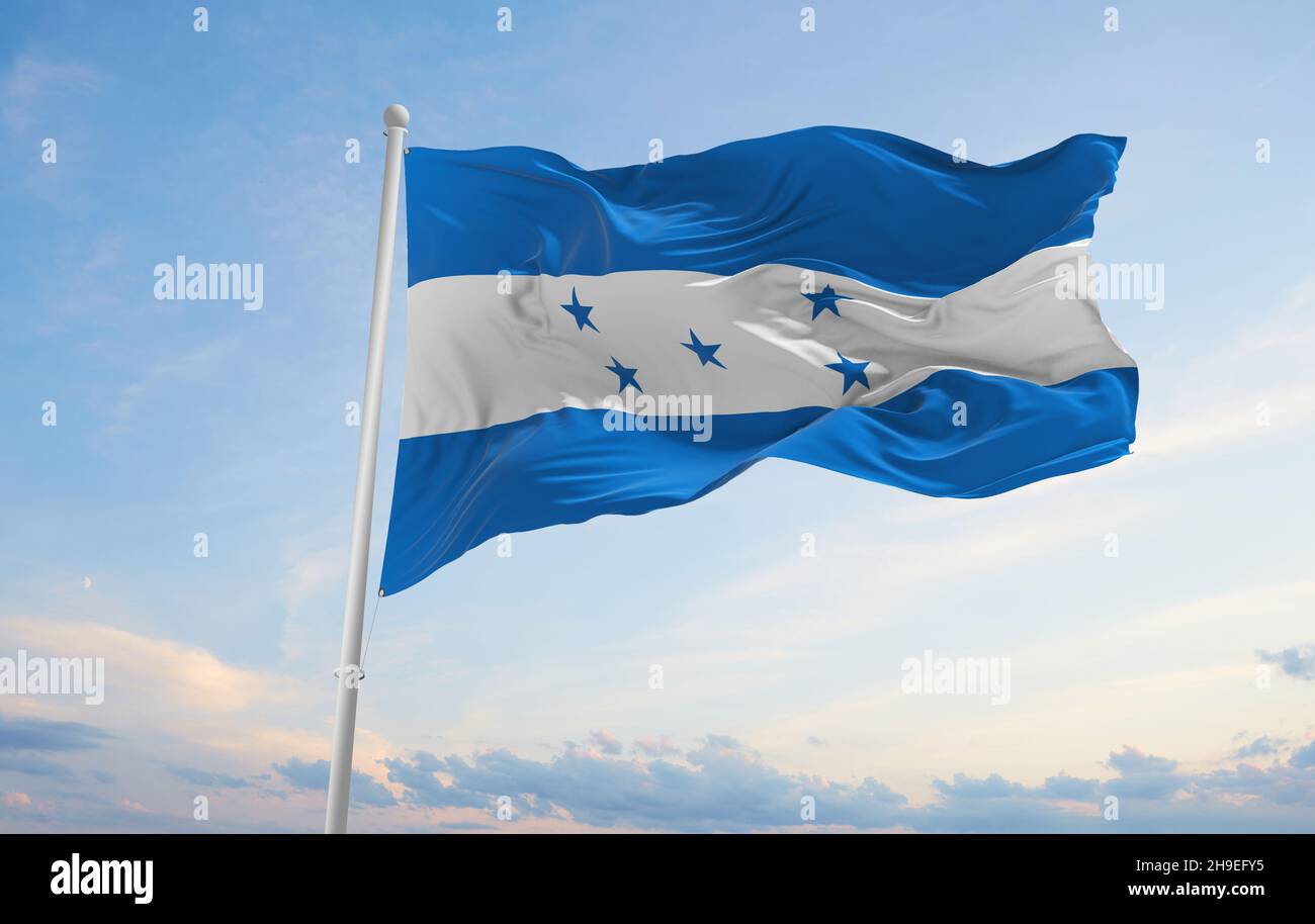 official flag of Honduras at cloudy sky background on sunset, panoramic ...