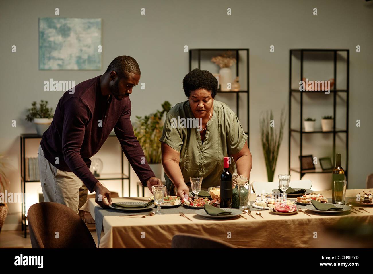 Waist up portrait of two African-American people serving table for ...