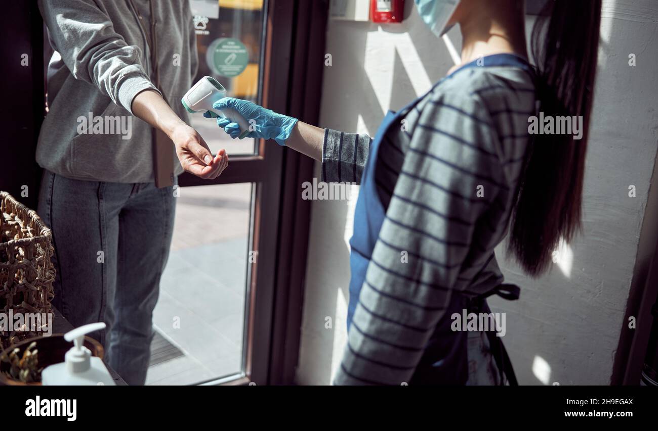 Customer going through temperature check before entering cafe Stock ...