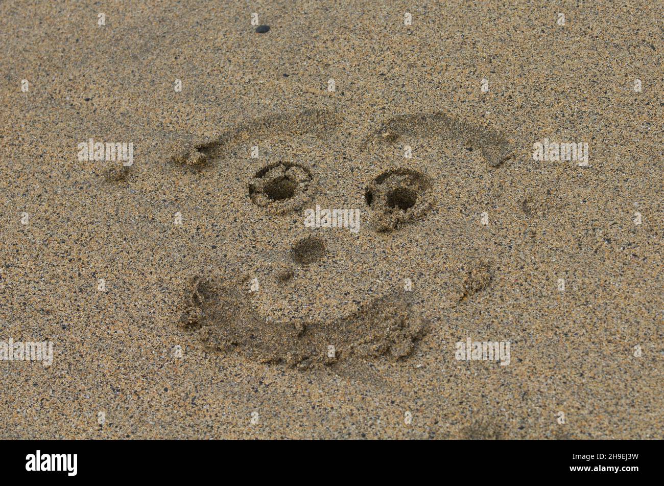 Smiley face drawn in beach sand Stock Photo - Alamy