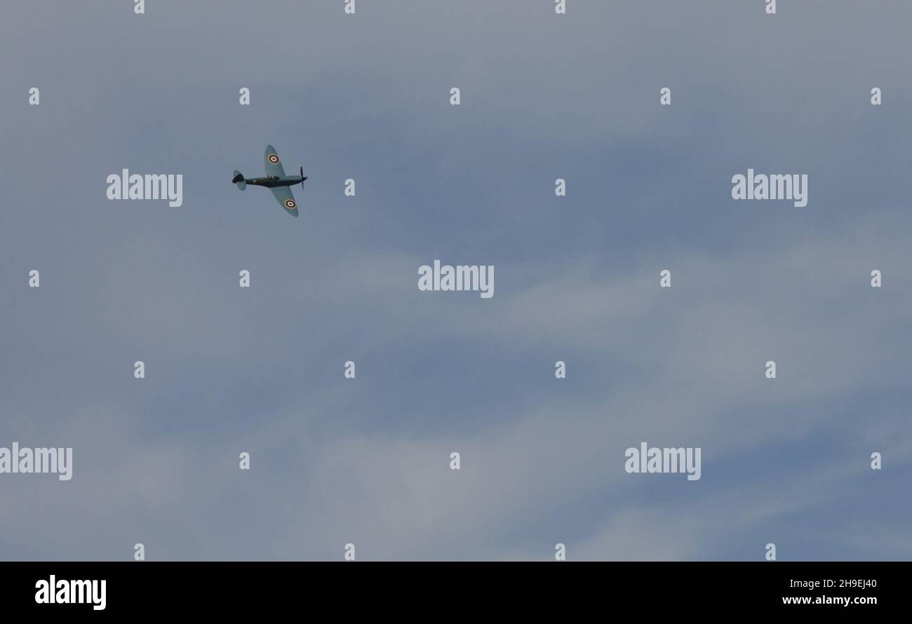 Supermarine Spitfire tuning in a blue sky. Powered by Rolls-Royce ...