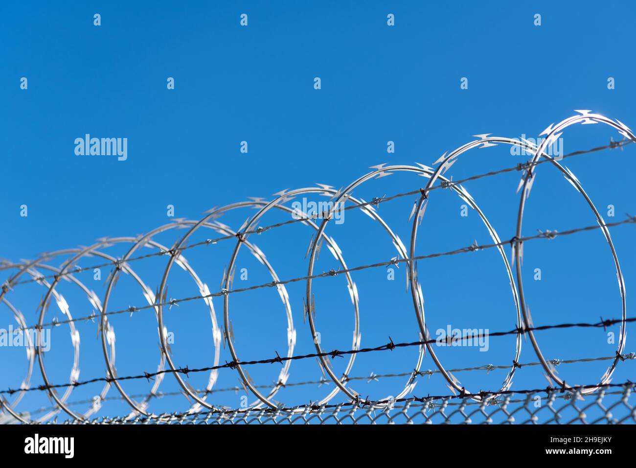 barbwire prison wall with barbed wire fence coiled razor wire perimeter ...