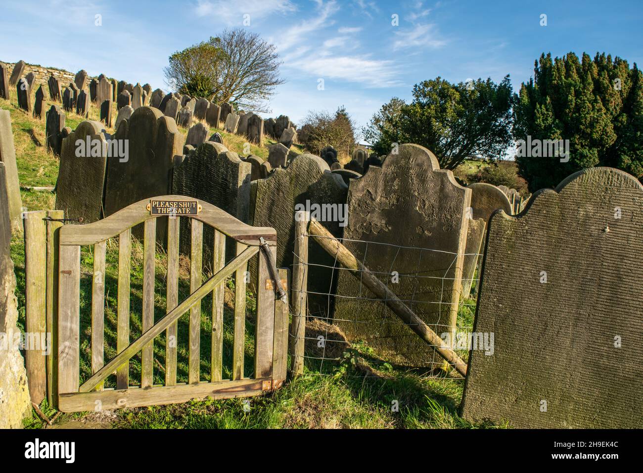 Wooden cross in graveyard next to headstone hi-res stock photography ...
