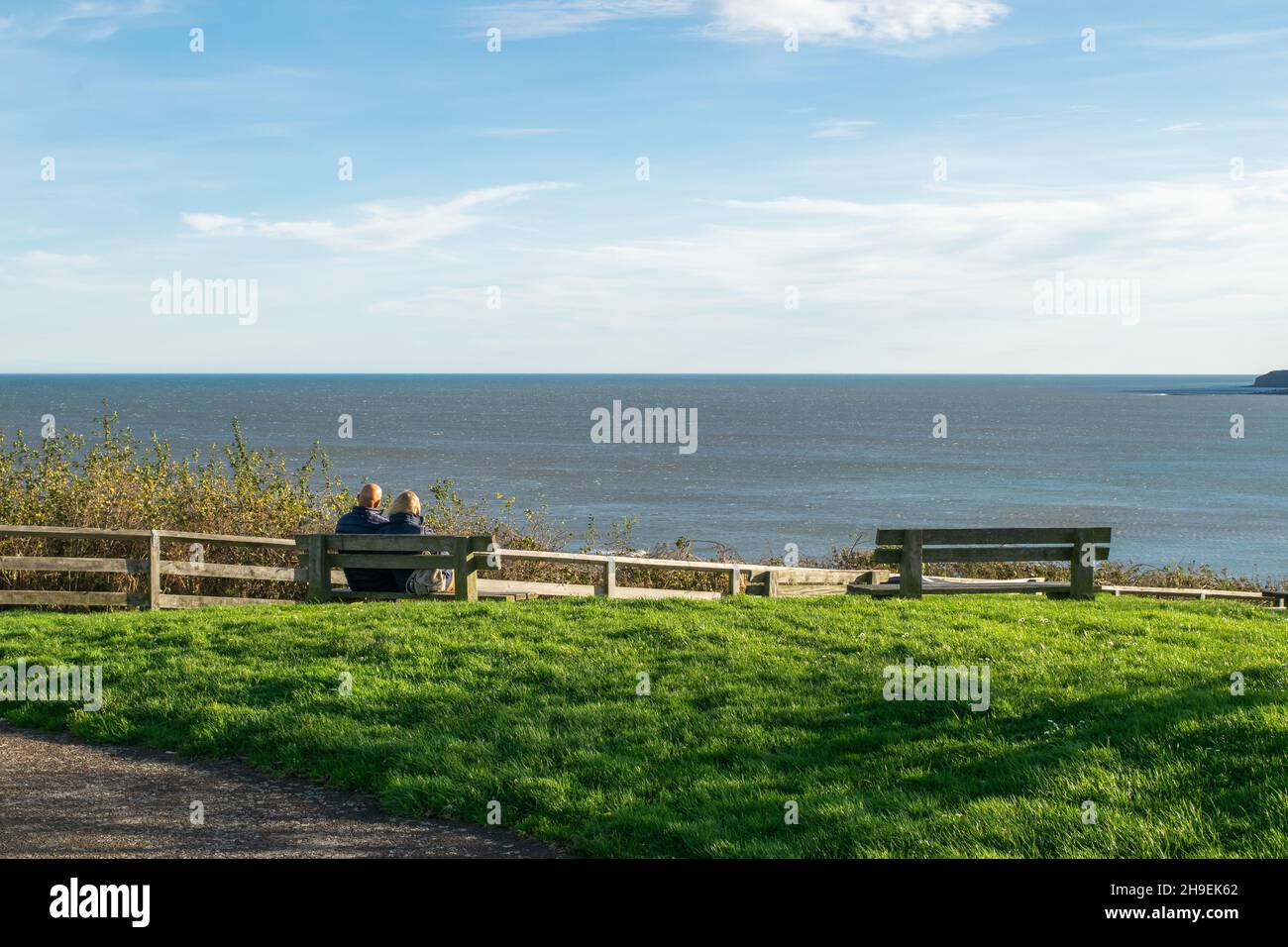 Old couple sit on bench enjoying the sea view in England Stock Photo ...