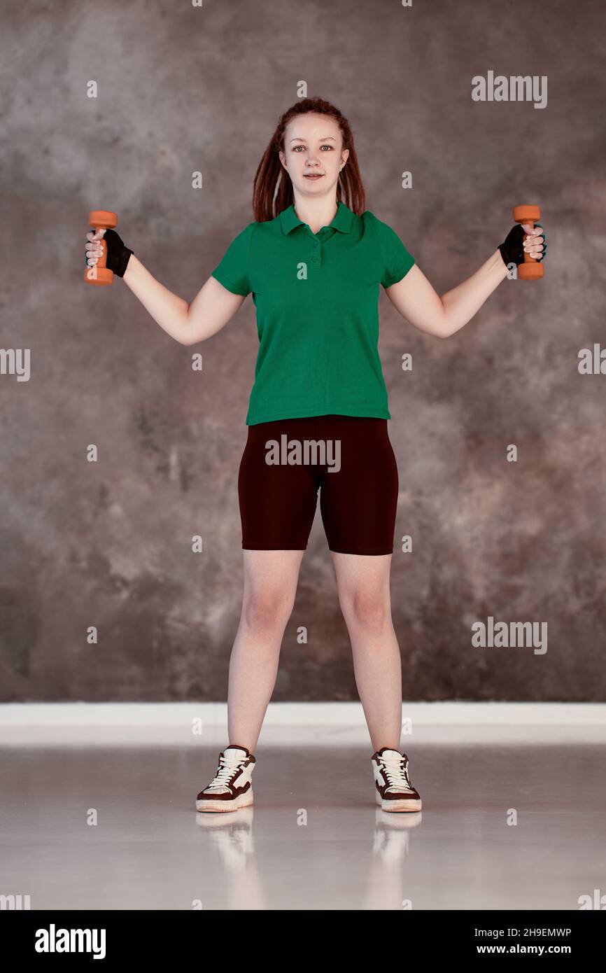 Strength training with dumbbells, woman spreads her arms to sides Stock ...