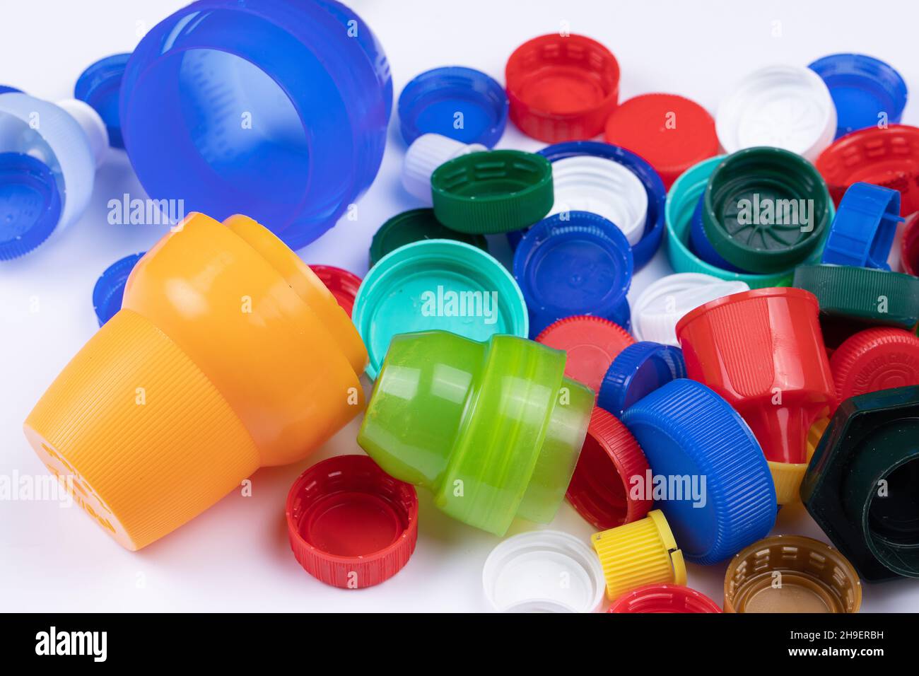Closeup of vibrant and colorful plastic container caps on a white ...