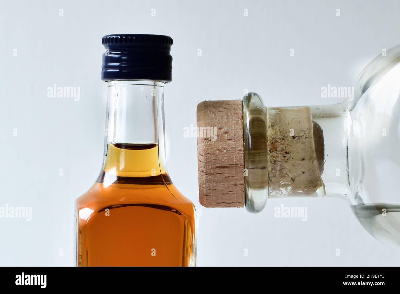 Two bottles with alcohol close up on blurred white background on ...