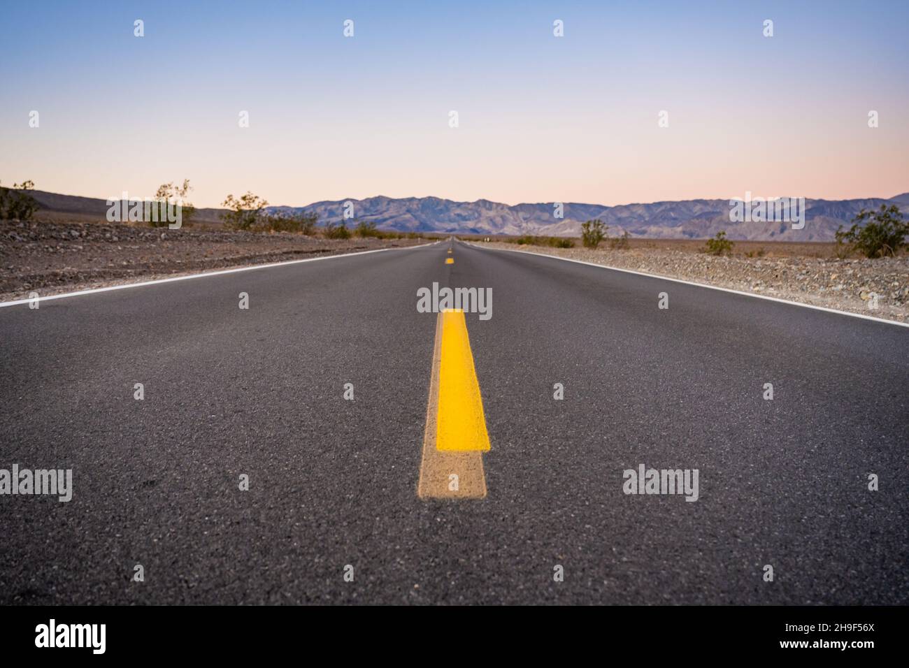 Low Angle of Bright Yellow Stripe On Road In Death Valley Stock Photo ...