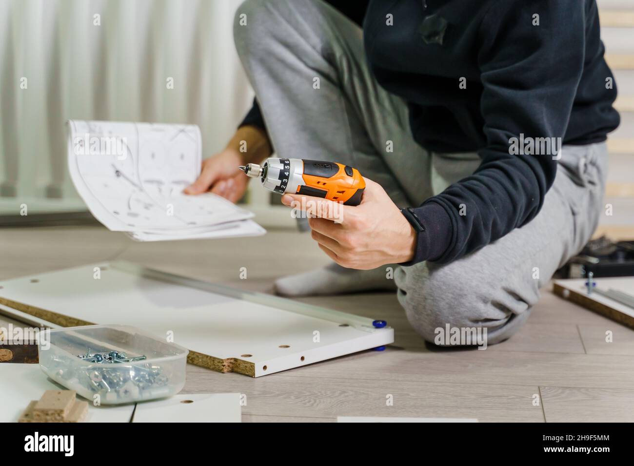 One unknown Man alone Putting Together Self Assembly Furniture sitting ...