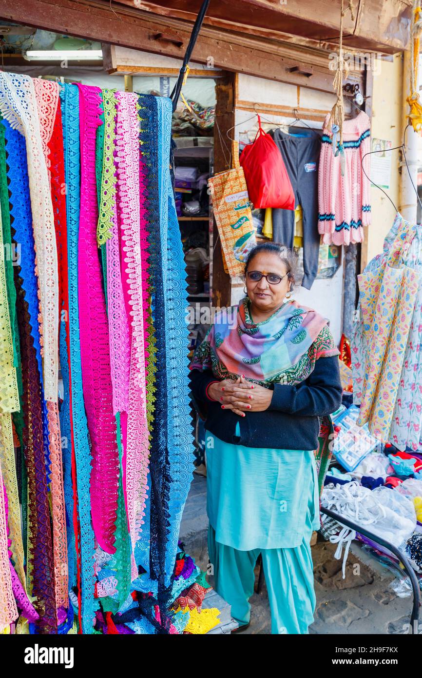 A local elderly female shopkeeper tends a fabric shop in Pragpur, a ...