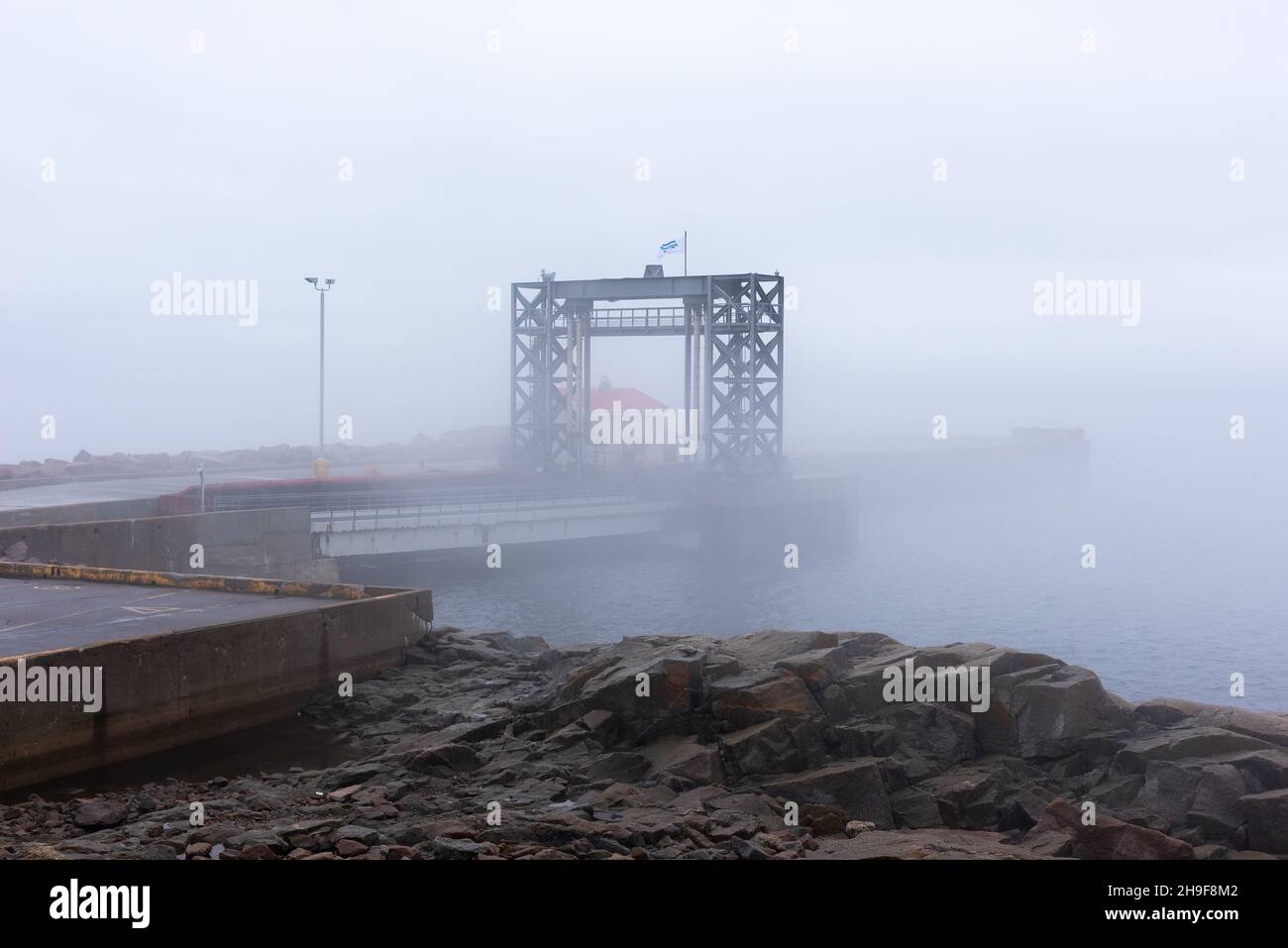 In the fog, the pier of the ferry crossing the St Lawrence river ...