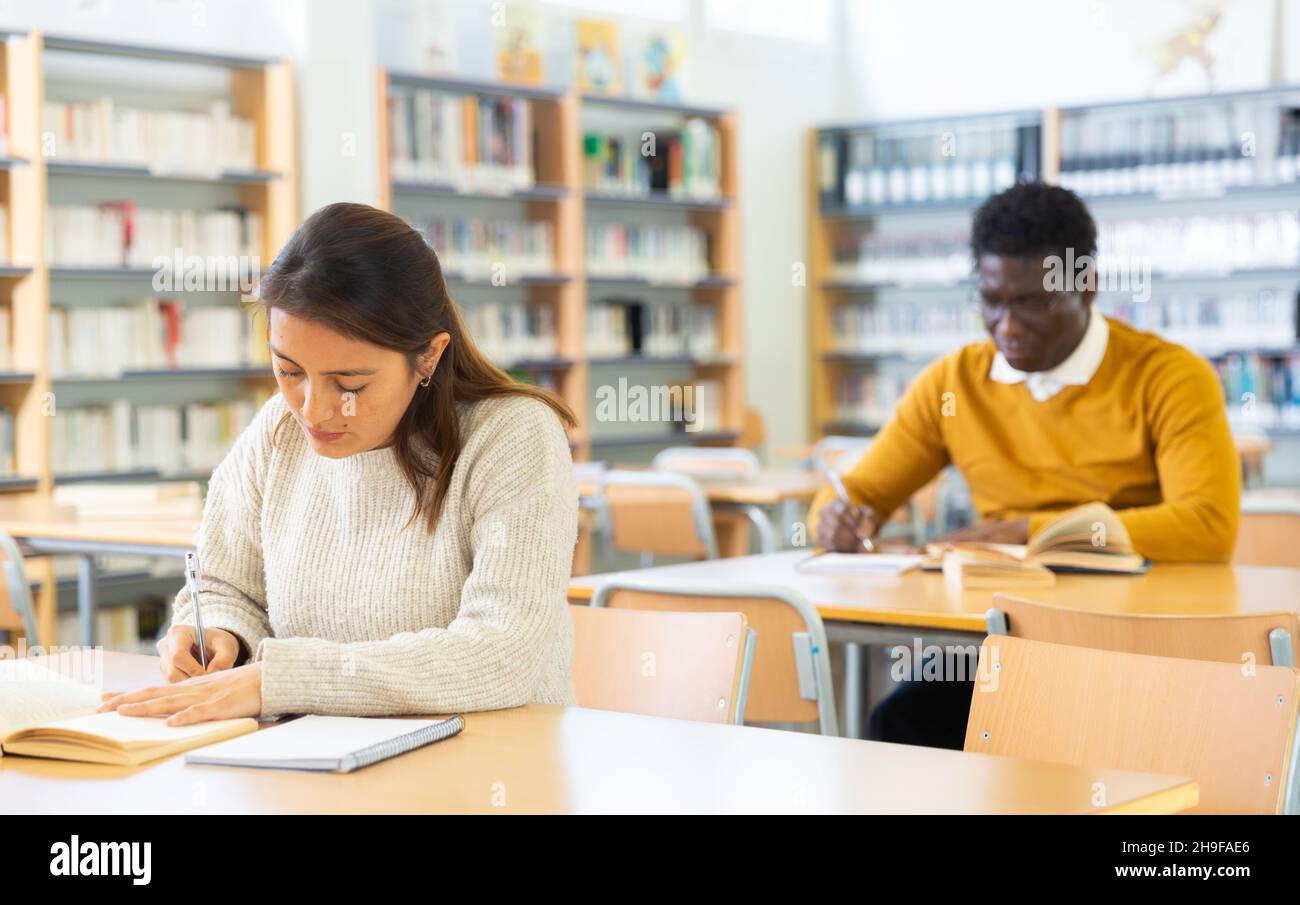 Young adult woman studying in public library Stock Photo - Alamy