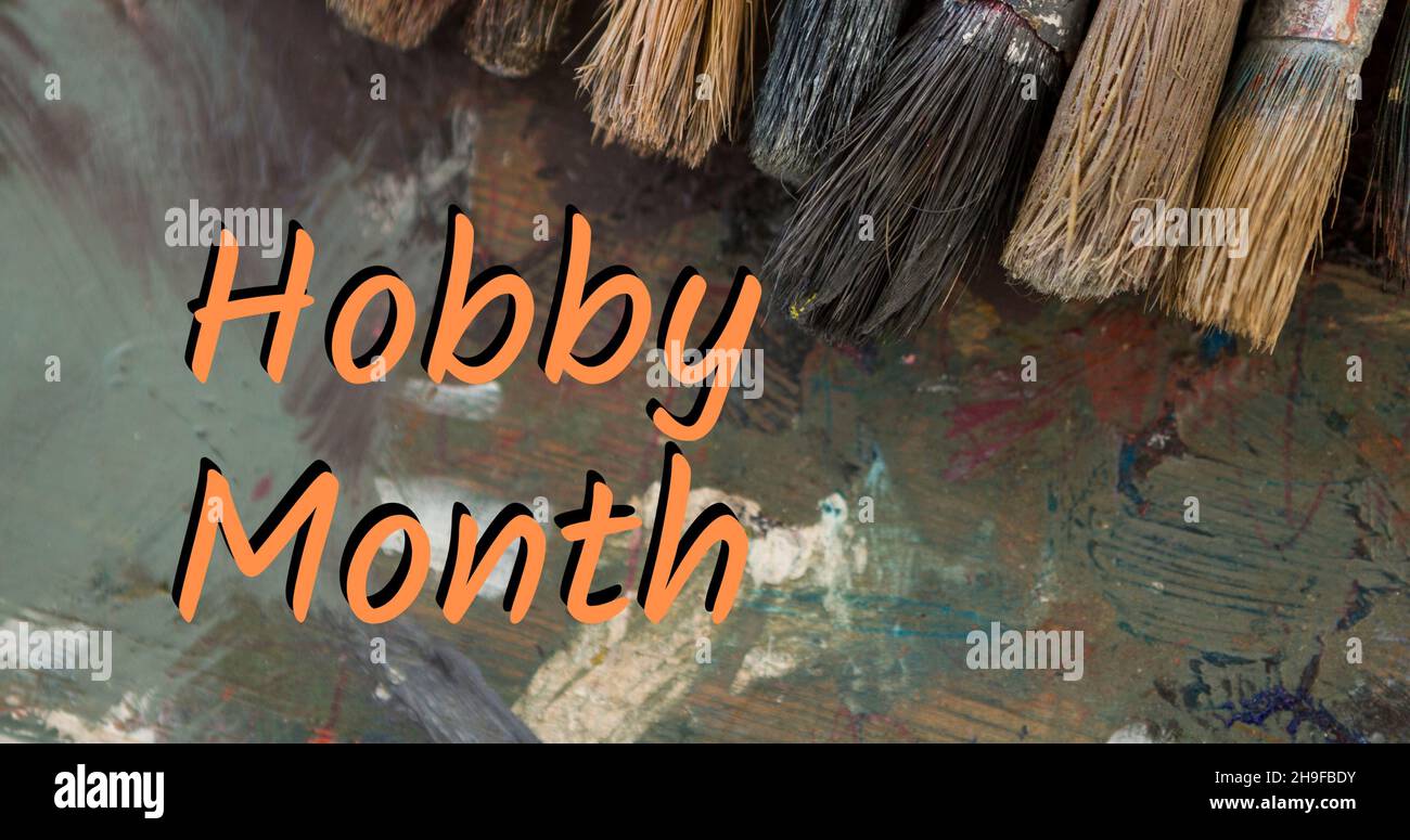 Composition of hobby month text with paintbrushes on messy table, copy ...
