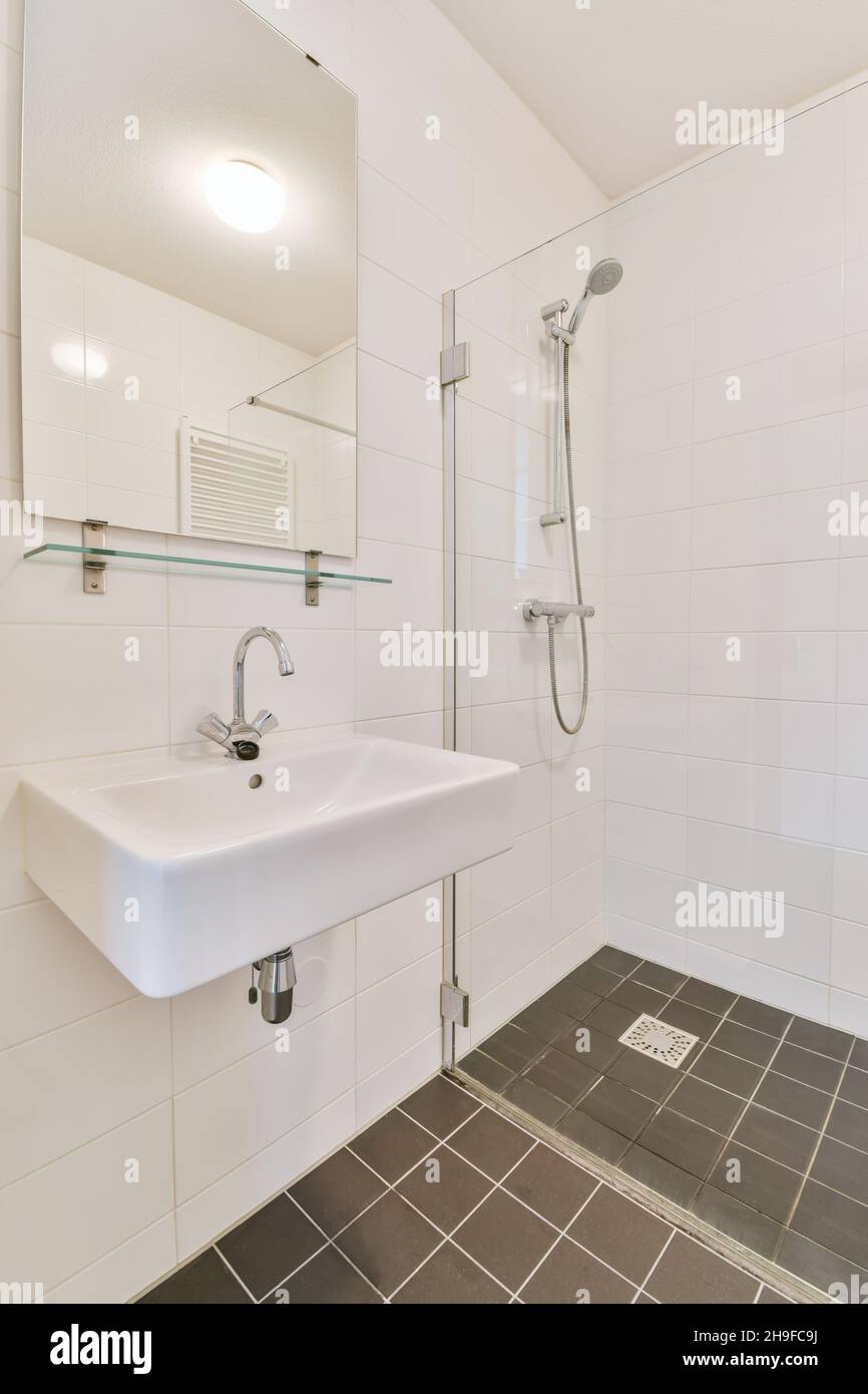 Stylish bathroom with brown tiled floor and glass-enclosed walk-in ...