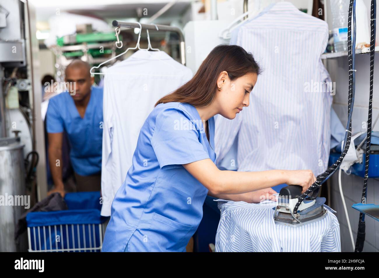 Female laundry worker ironing hi-res stock photography and images - Alamy