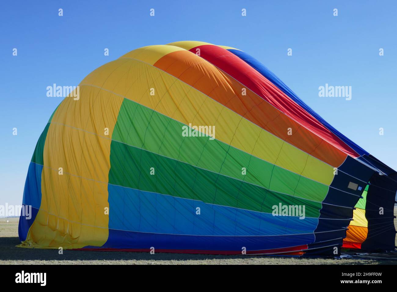 Colorful hot air balloon halfway inflated Stock Photo - Alamy